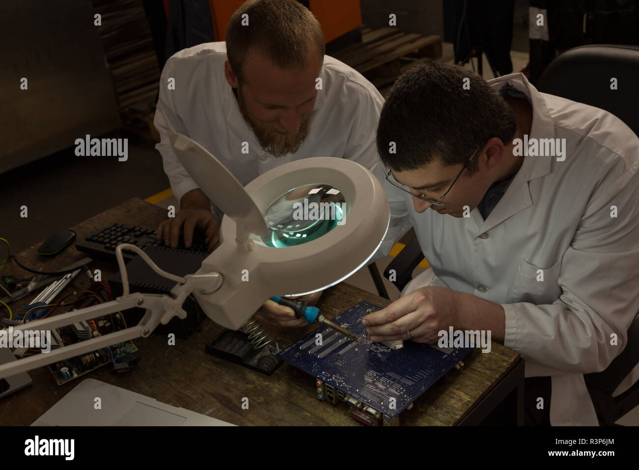 Robotics engineers assembling circuit board at desk Stock Photo - Alamy