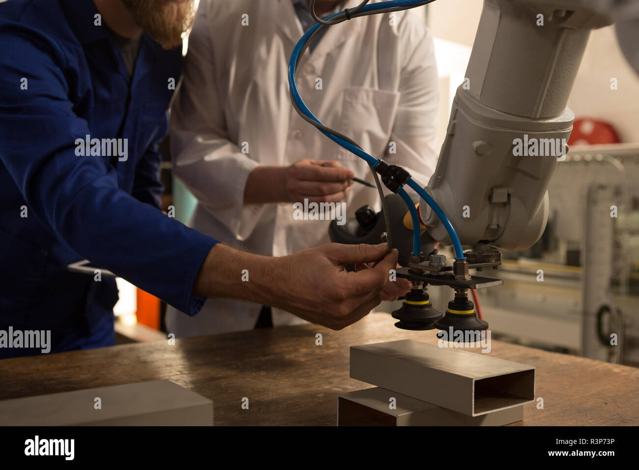 Robotic engineers testing robotic machine Stock Photo - Alamy