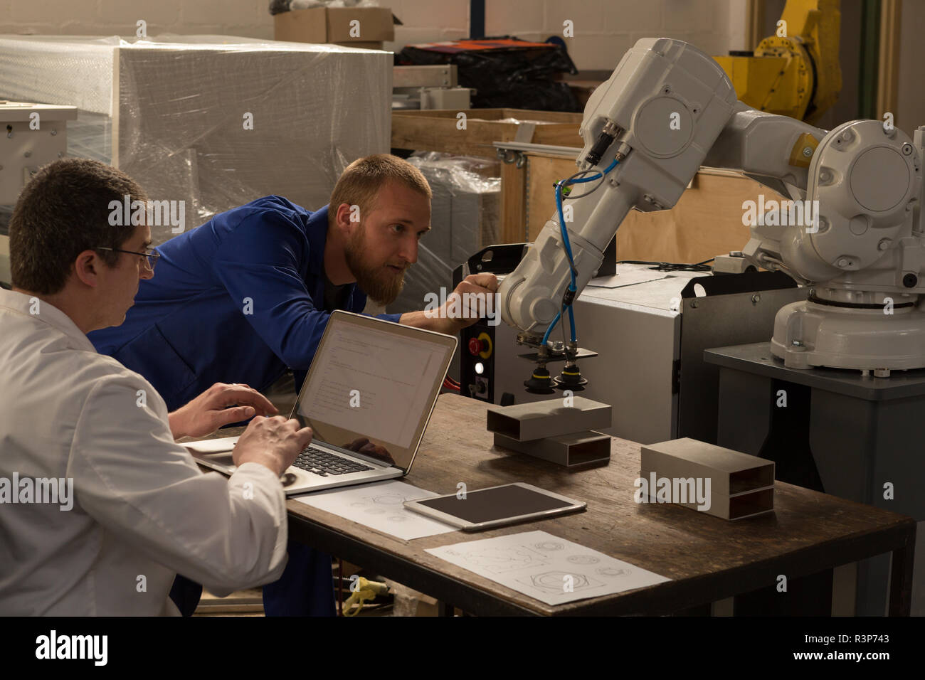 Robotic engineers examining robotic machine Stock Photo - Alamy