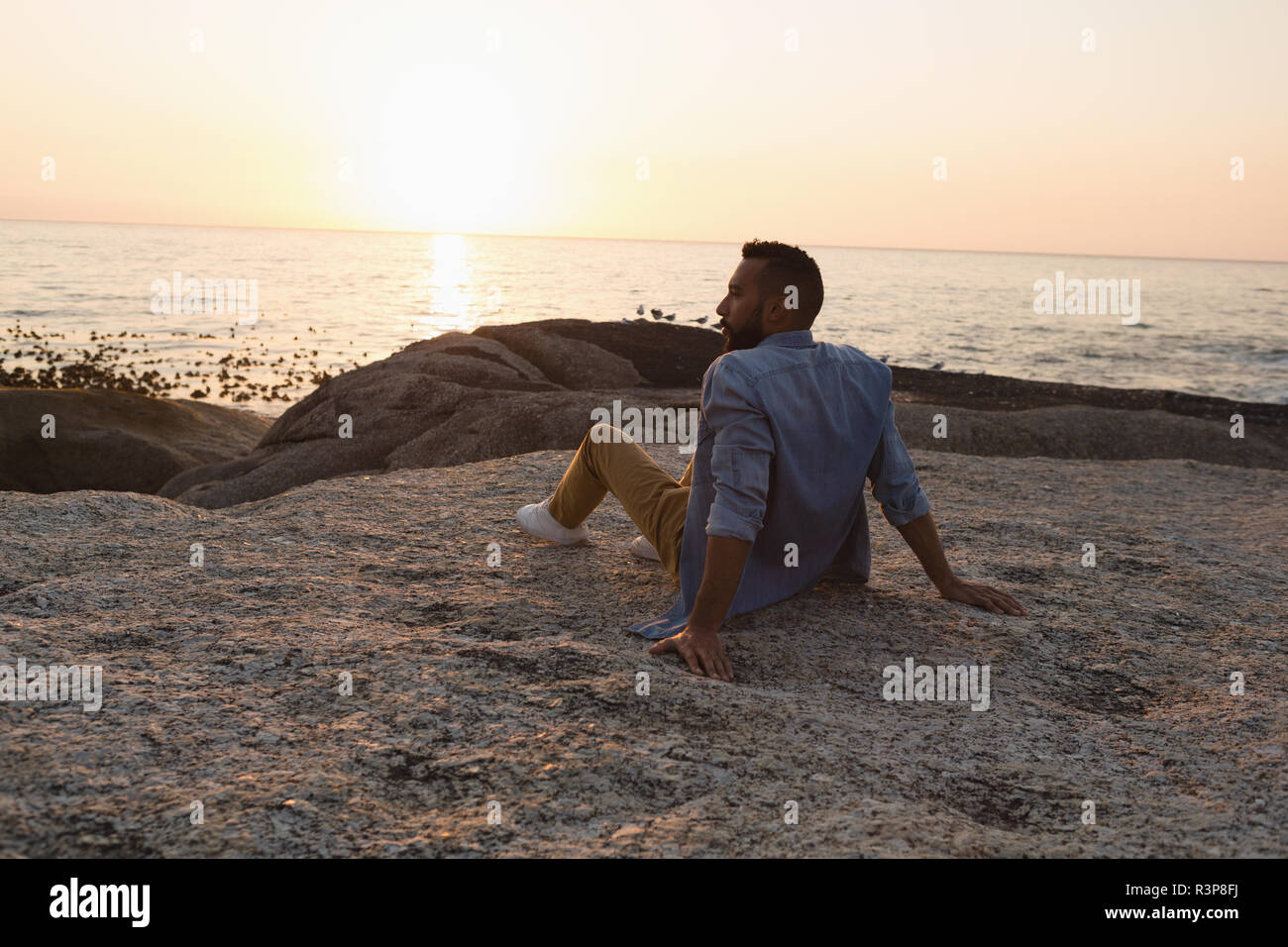 Man sitting on beach Stock Photo - Alamy
