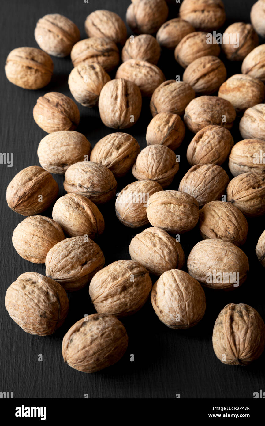 Whole walnuts on black background, side view. Closeup Stock Photo - Alamy