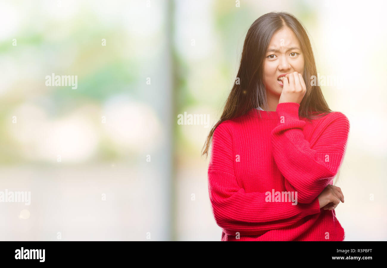 Young asian woman wearing winter sweater over isolated background ...
