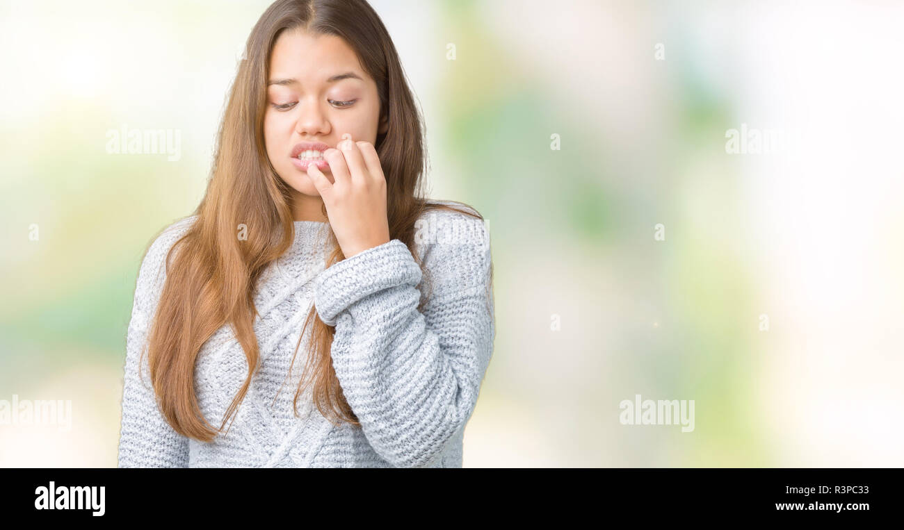Young beautiful brunette woman wearing sweater over isolated background ...