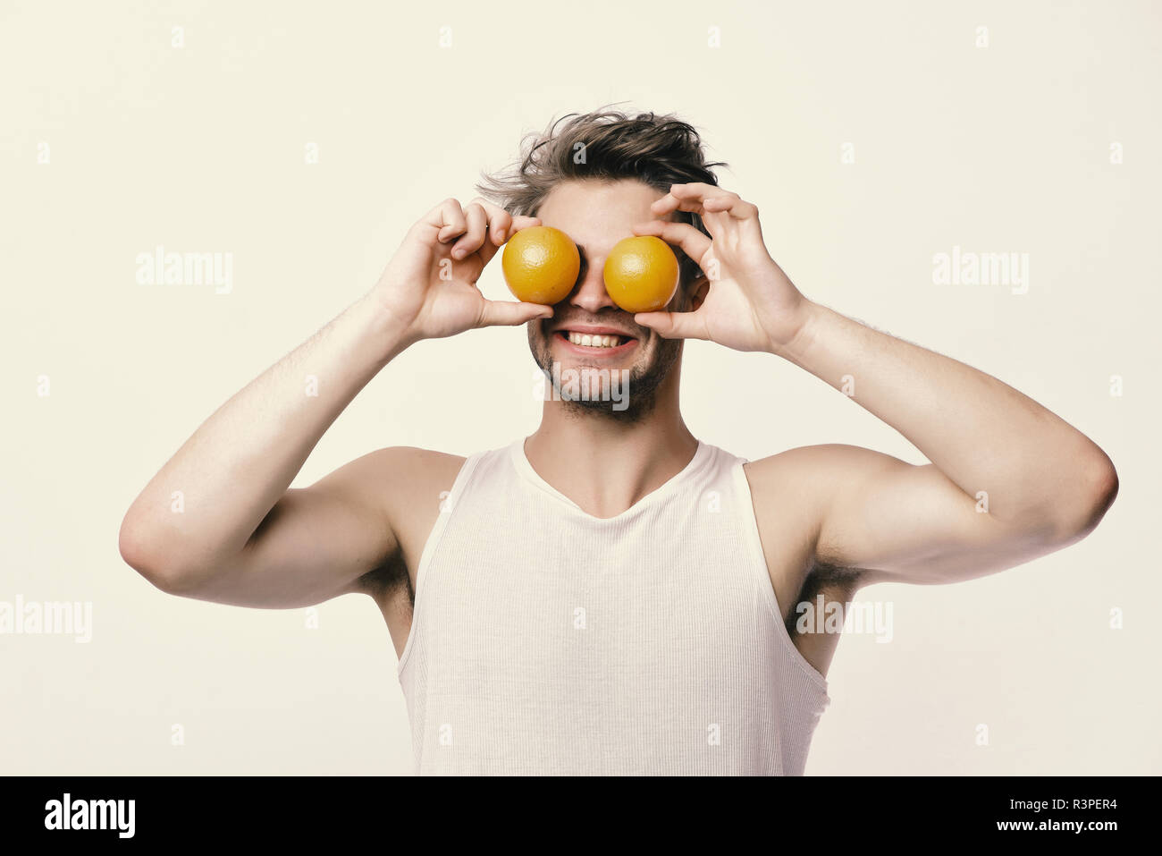 Healthy nutrition concept. Athlete with messy hair holds fresh fruit ...