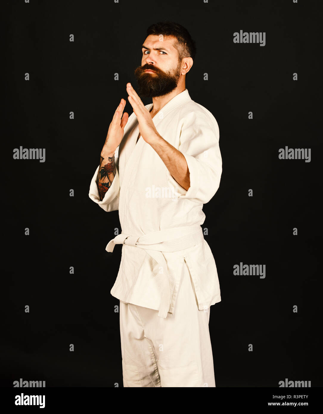Oriental sports concept. Man with beard in white kimono on black ...