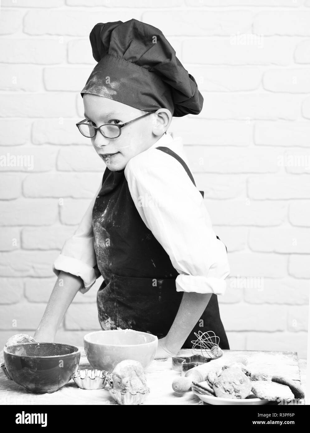 young boy cute cook chef in red uniform and hat on stained face with ...