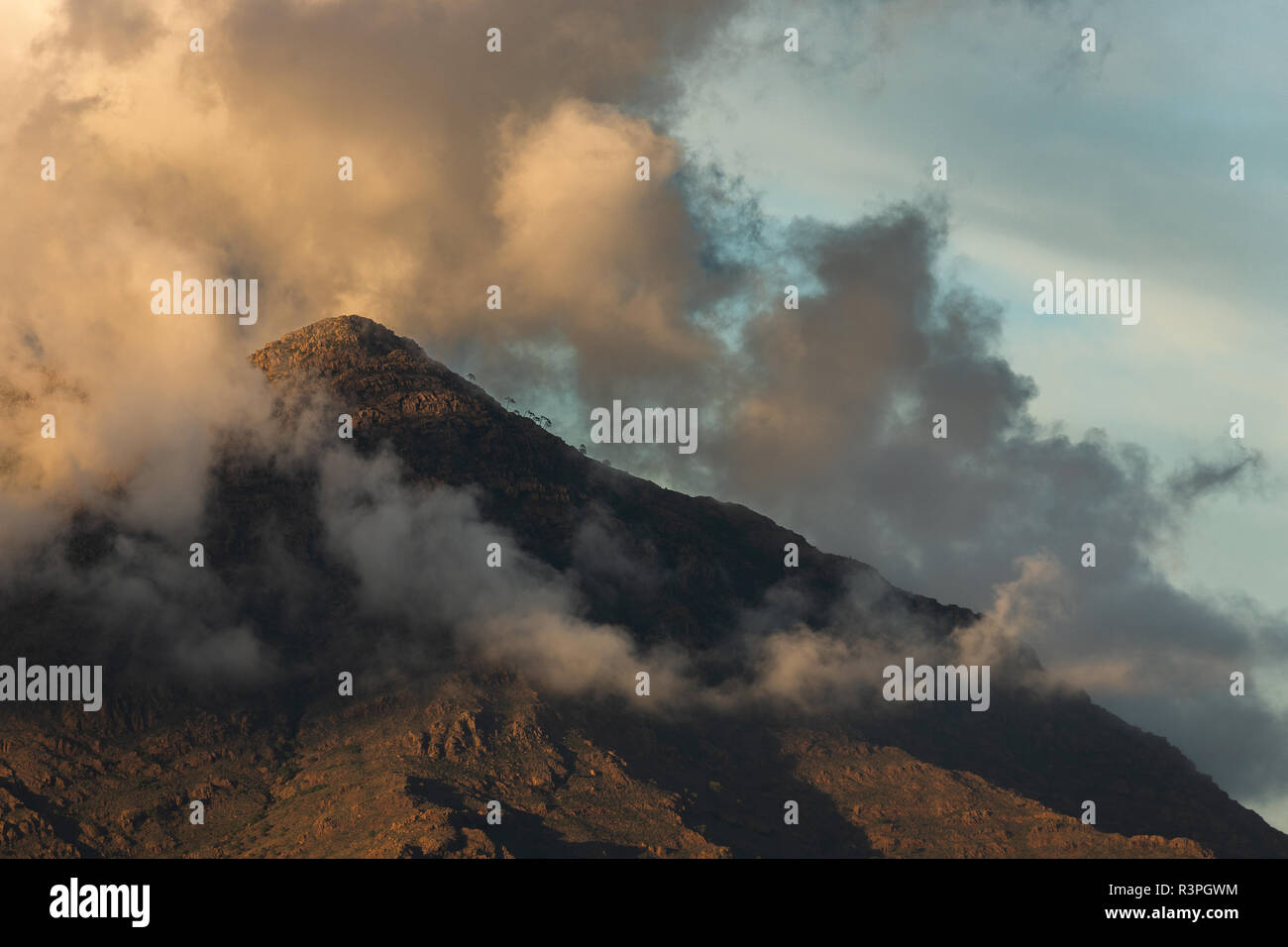 Mountains at sunset through clouds Stock Photo - Alamy