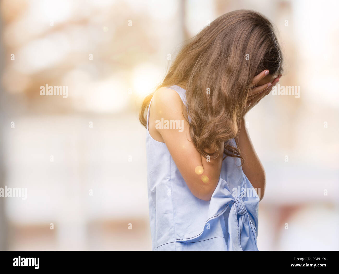 Brunette hispanic girl with sad expression covering face with hands ...