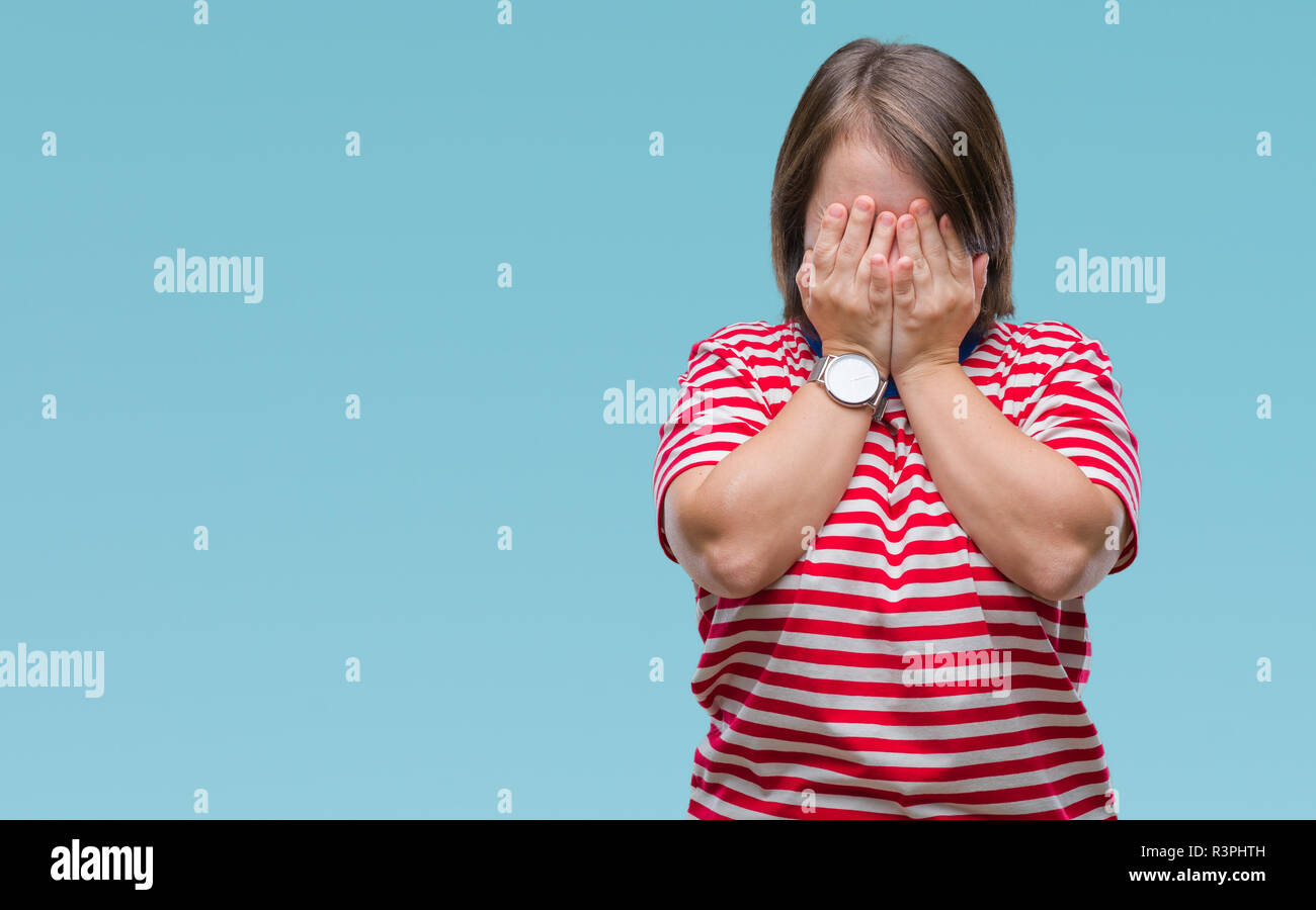 Young adult woman with down syndrome over isolated background with sad ...