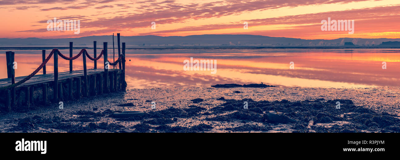 Sunrise of a wooden pier over a lake Stock Photo - Alamy
