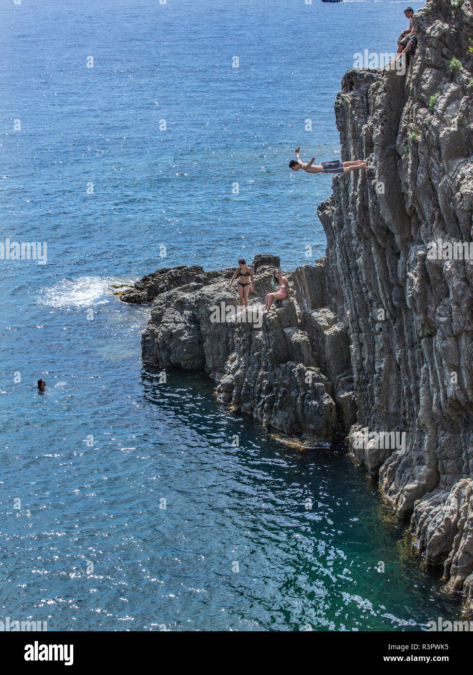 Leaping off a cliff in Italy Stock Photo - Alamy
