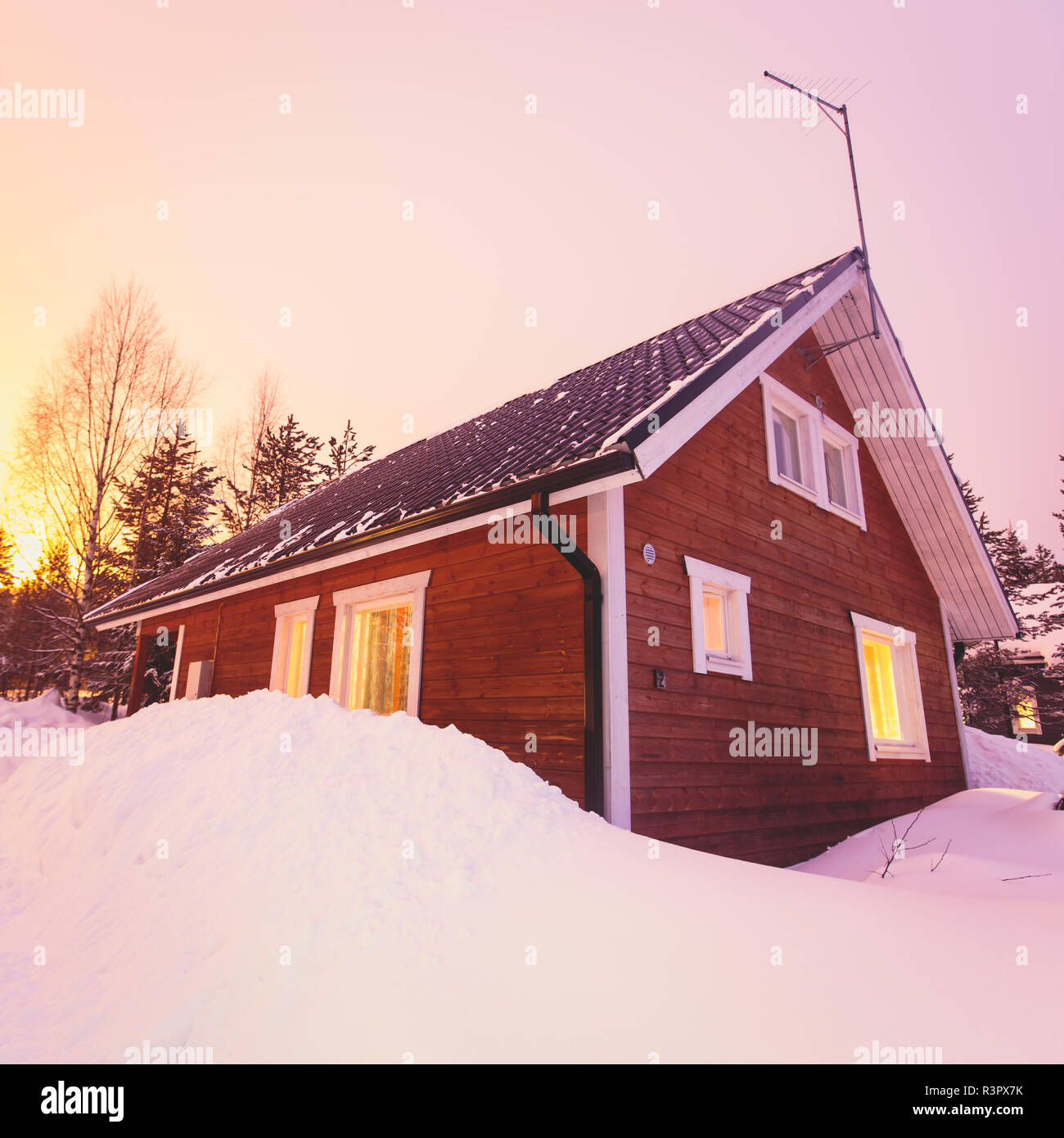 A cozy wooden cabin cottage chalet house covered in snow near ski ...