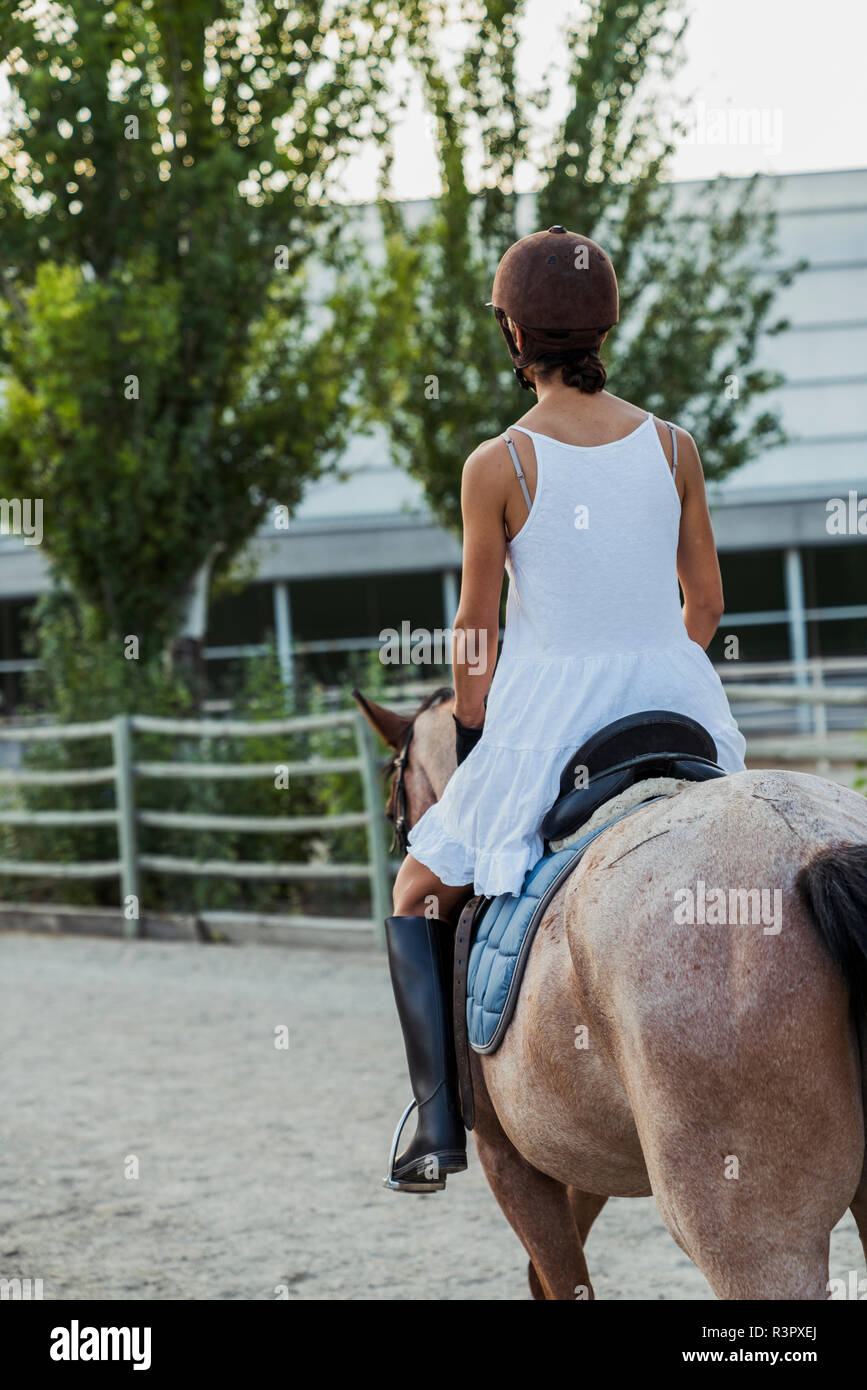 Back view of woman riding on horse Stock Photo - Alamy