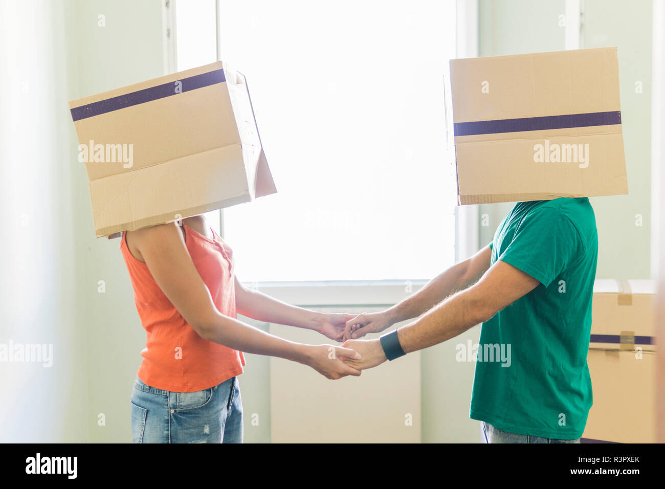 Couple heads cardboard boxes holding hands hi-res stock photography and ...