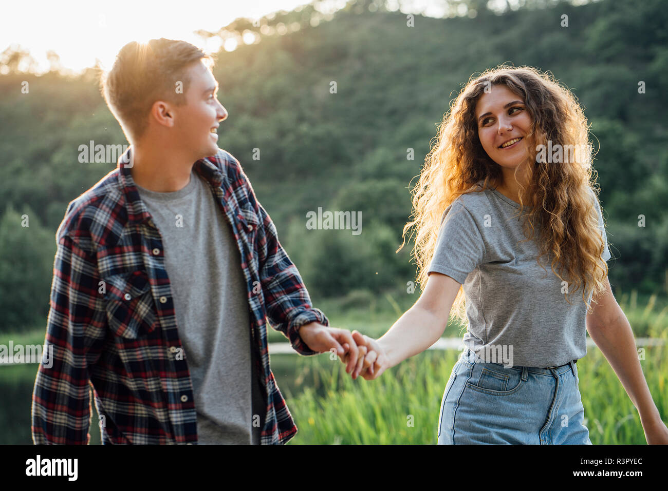 Romantic couple spending time in nature, holding hands Stock Photo - Alamy