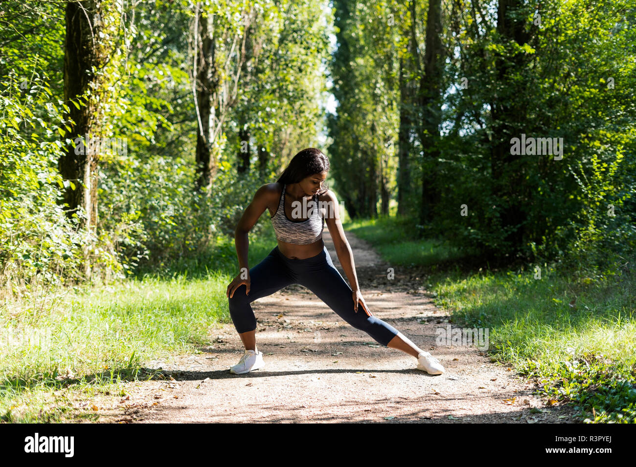 Female athlete warming up for workout in nature Stock Photo - Alamy