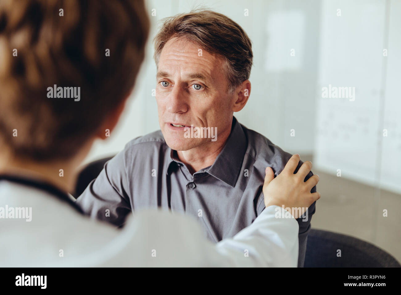 Female doctor calming worried patient Stock Photo - Alamy