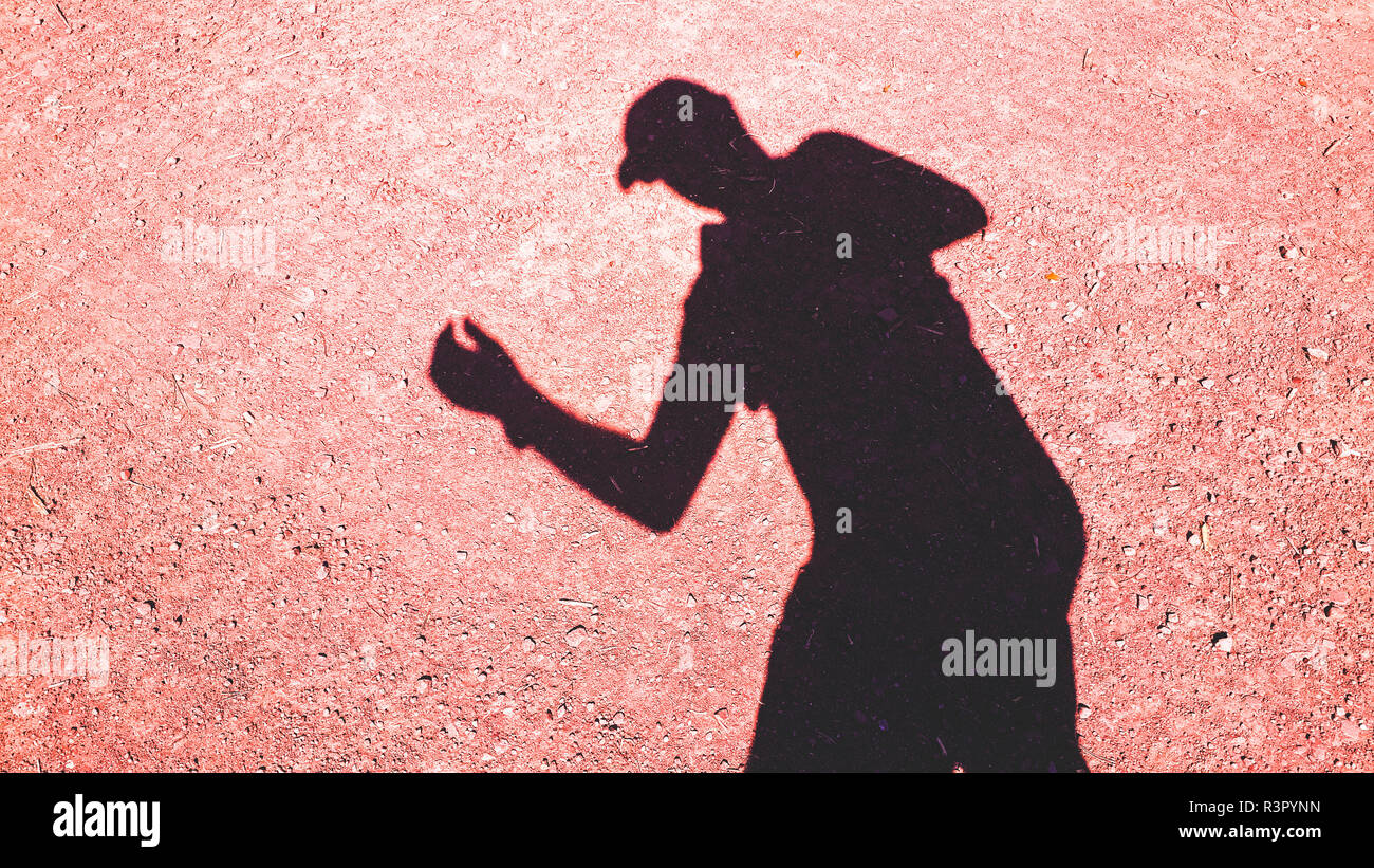 Shadow on the ground of a runner with a cap in summer with a lot of ...