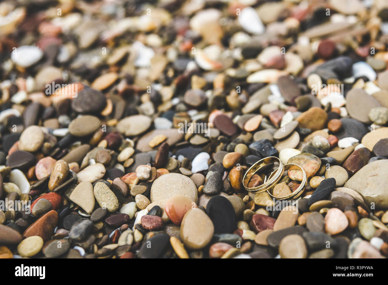 Gold wedding rings on the rocks of a beach Stock Photo - Alamy
