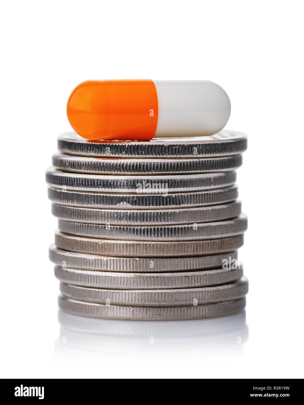 Capsule on a stack of coins isolated on white background. Concept on ...