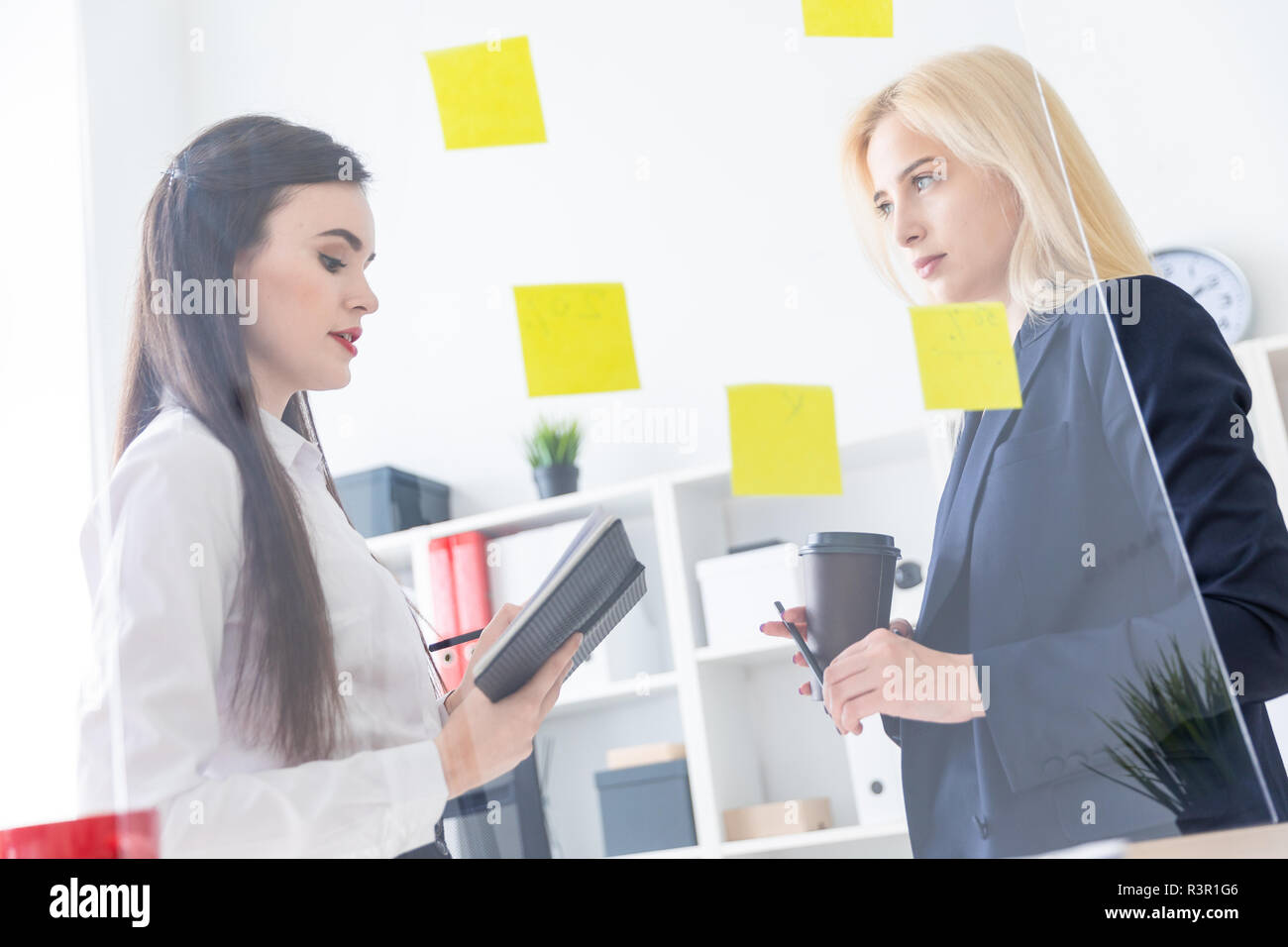 Two girls talking in the office. Girls are a dialogue near a ...