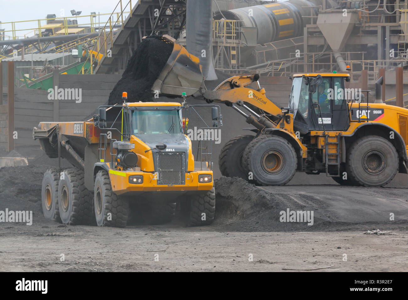 A Caterpillar 966 loading shovel loading a Caterpillar 400D ADT on the ...