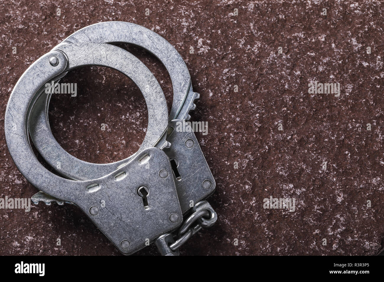 Top view of the handcuffs in left side of stone surface with copy space ...