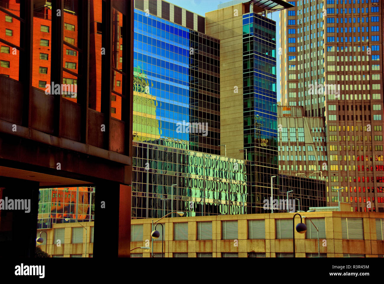 Mirrored city buildings in a variety of styles and angles create an ...