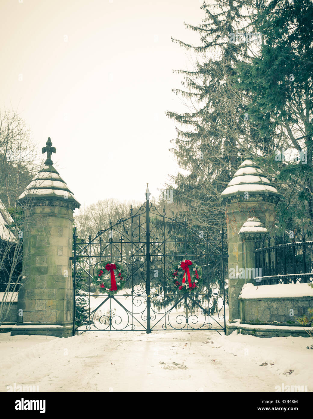 Old vintage cemetery gates architecture with snow and Christmas wreath ...