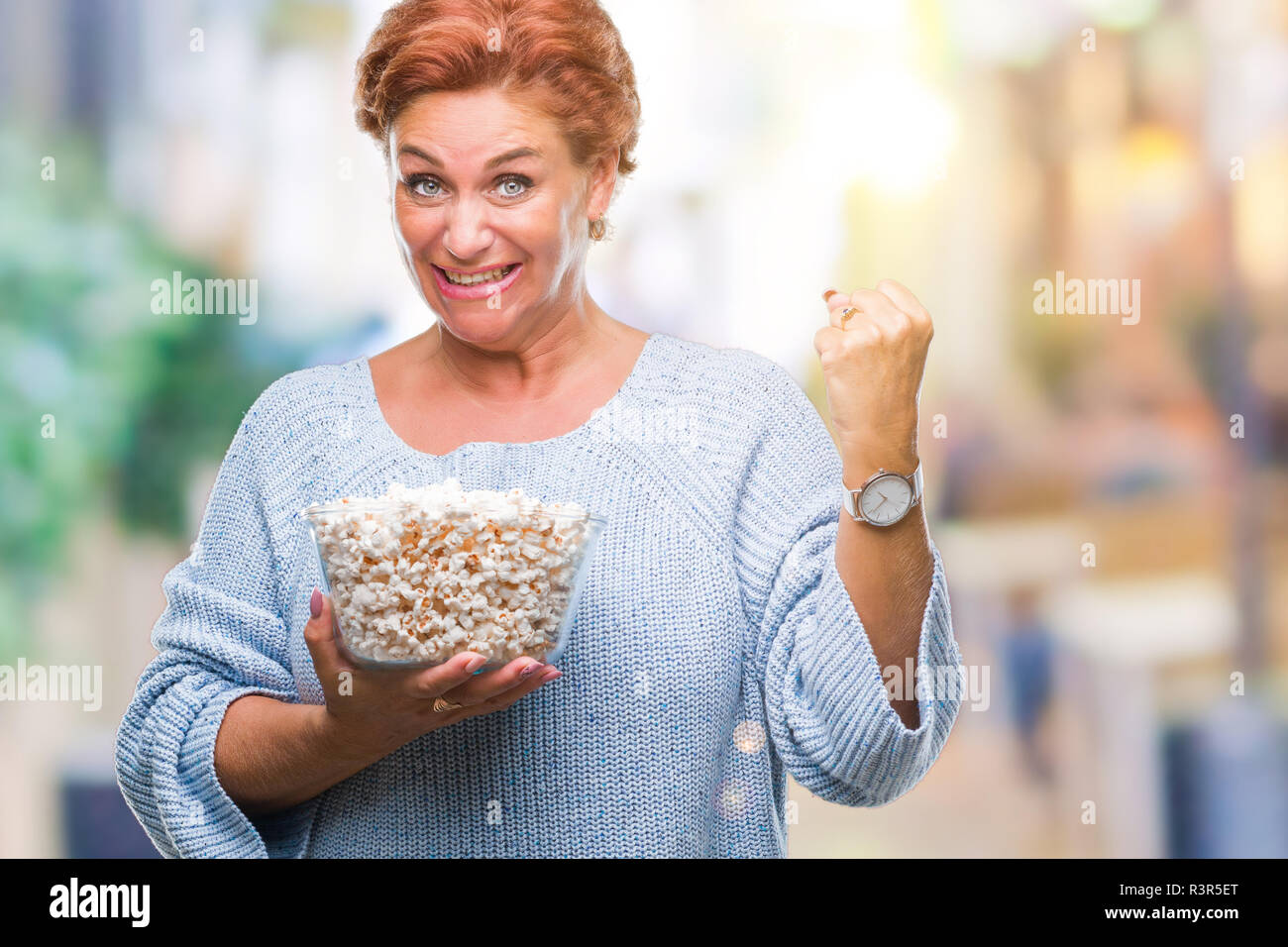 Atrractive Senior Caucasian Redhead Woman Eating Popcorn Over Isolated