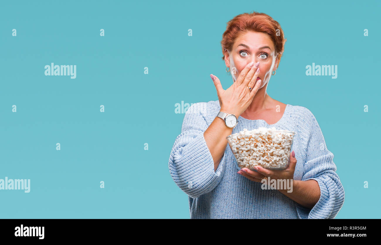 Atrractive Senior Caucasian Redhead Woman Eating Popcorn Over Isolated