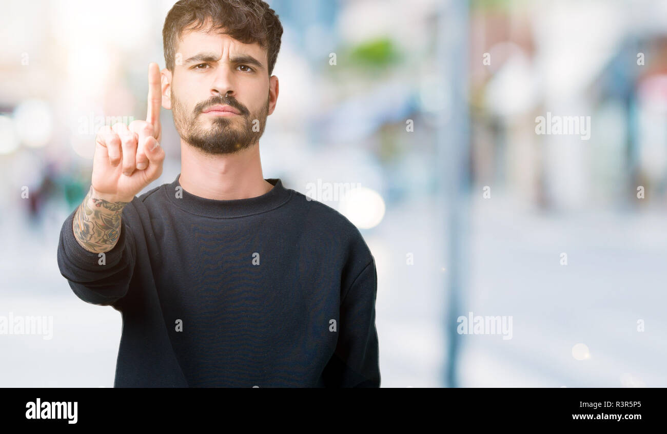 Young handsome man over isolated background Pointing with finger up and ...