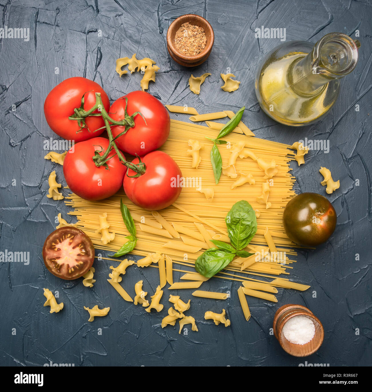 different types of pasta, laid out with various ingredients, tomatoes ...