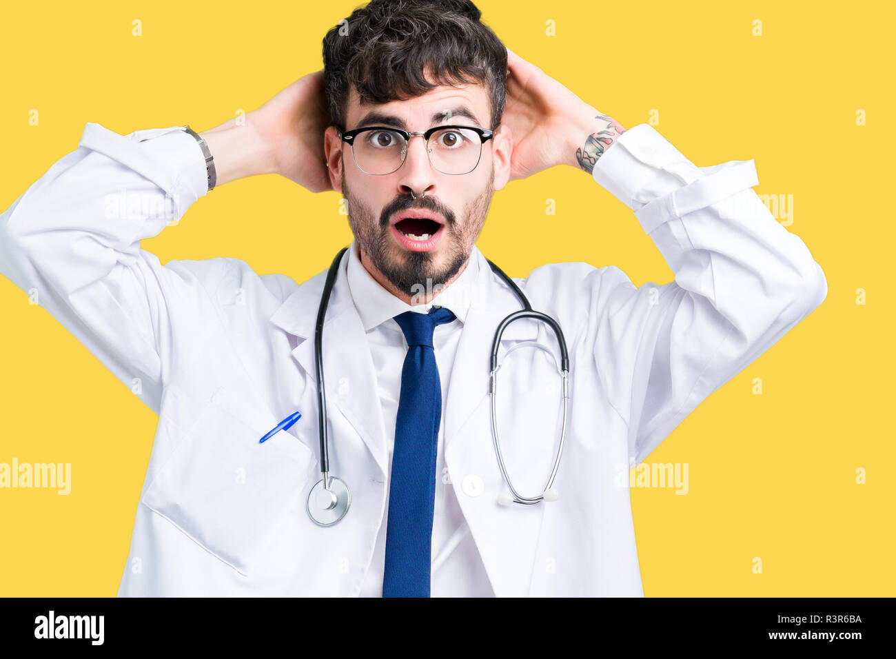 Young doctor man wearing hospital coat over isolated background Crazy ...