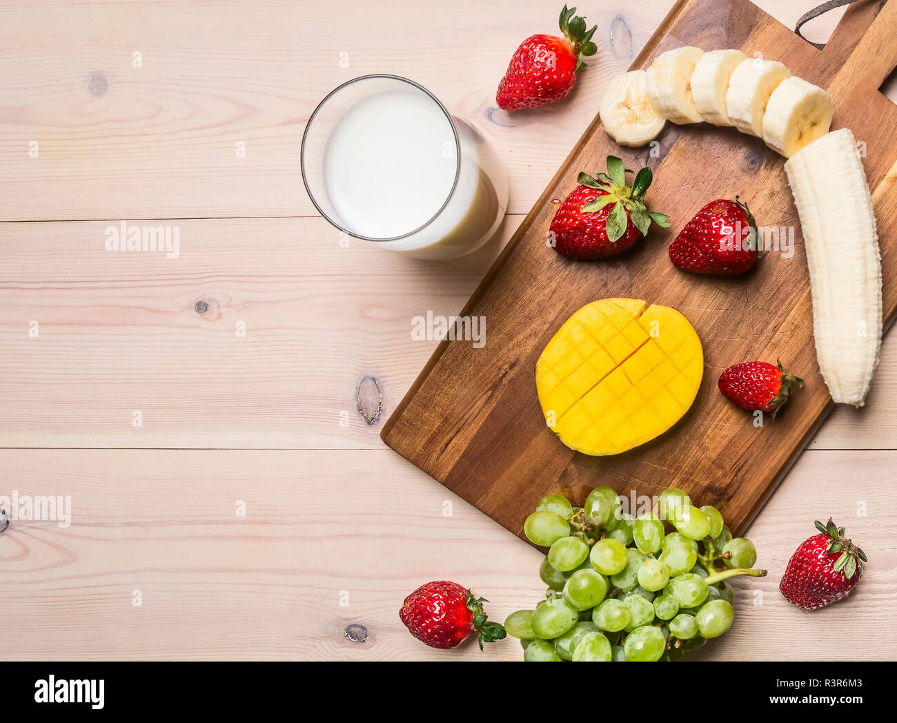 Fruits smoothies with various ingredients on white wooden background ...