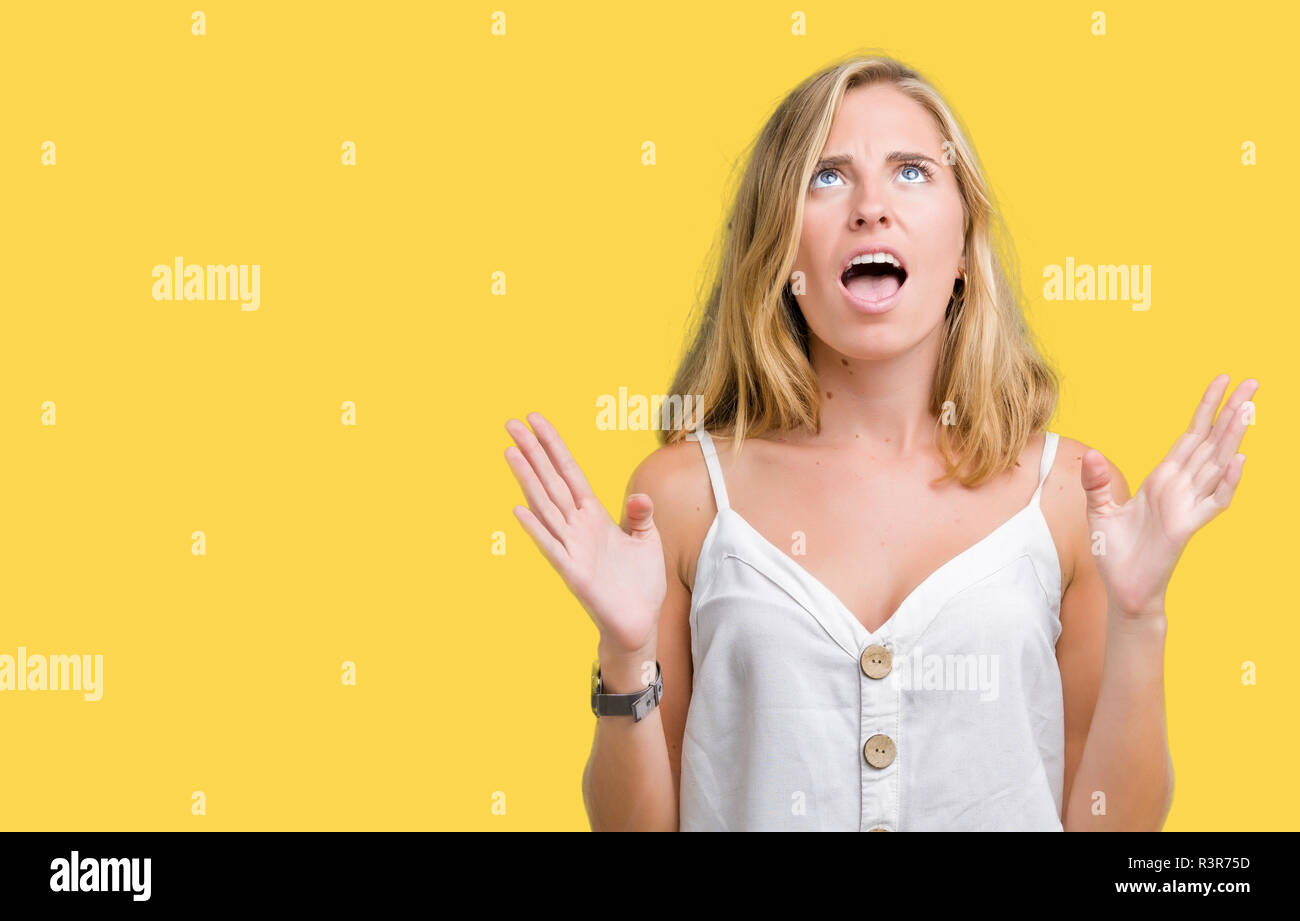 Beautiful young woman over isolated background crazy and mad shouting ...
