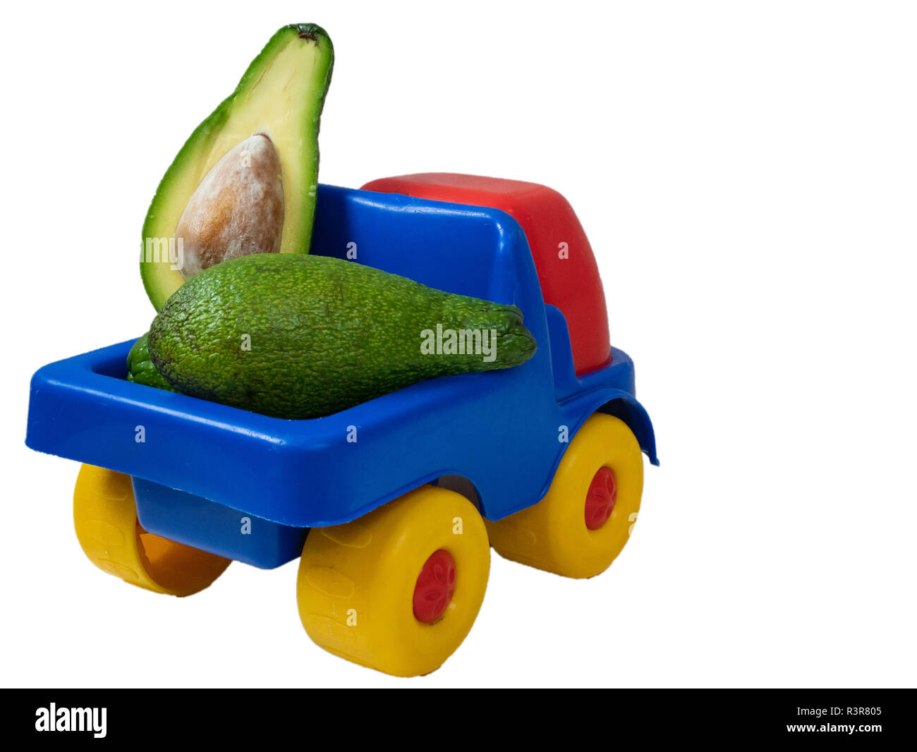 big toy truck with avocado fruit cut in a half. closeup from behind ...