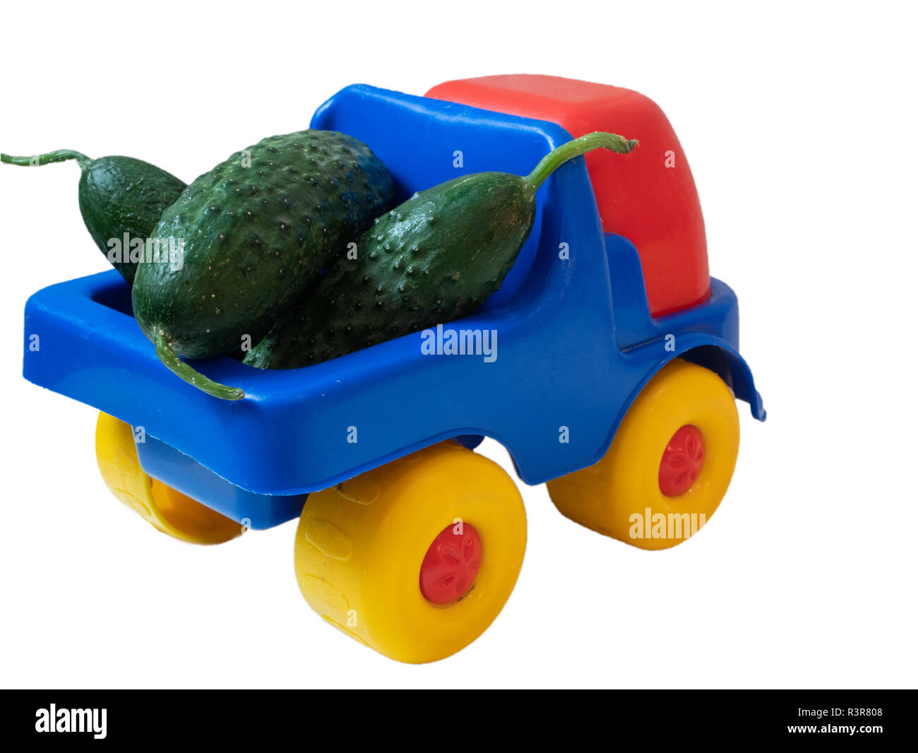 colorful vivid toy car truck with fresh green cucumbers. closeup from ...
