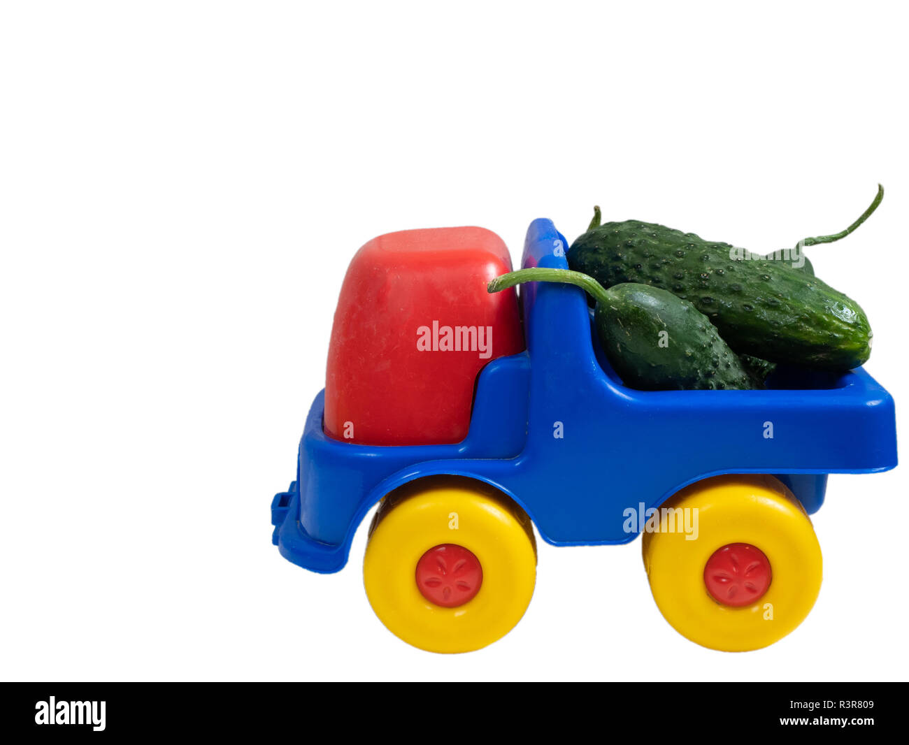 colorful vivid toy car truck with fresh green cucumbers. closeup side ...