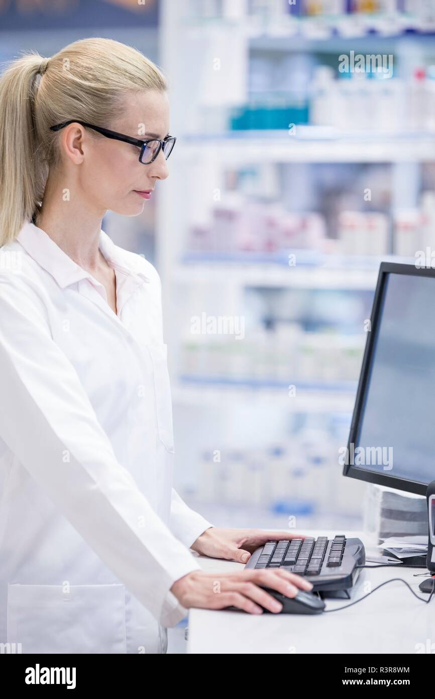 Female pharmacist working on computer in pharmacy Stock Photo - Alamy