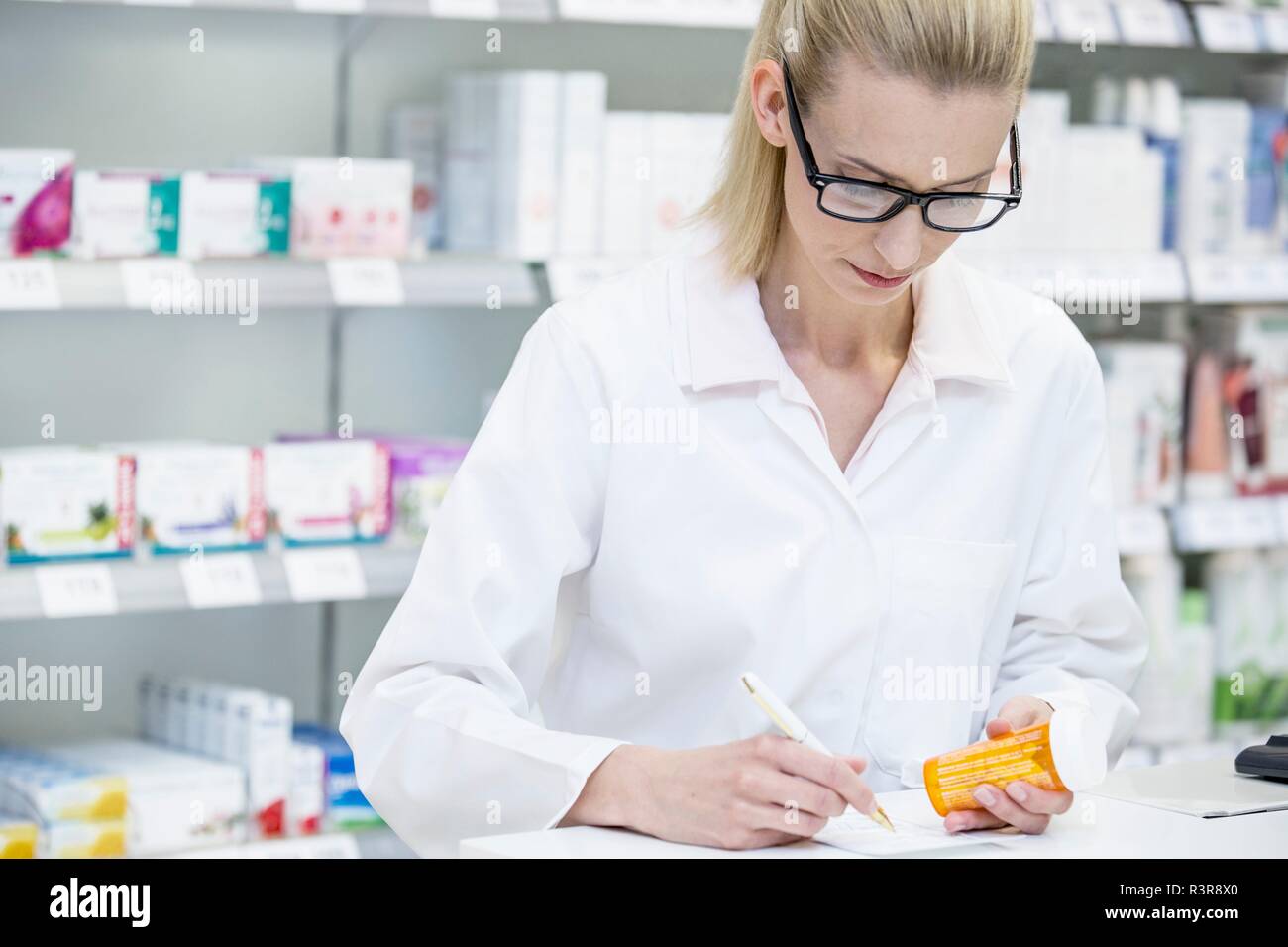 Pharmacist writing notes on a prescription Stock Photo - Alamy