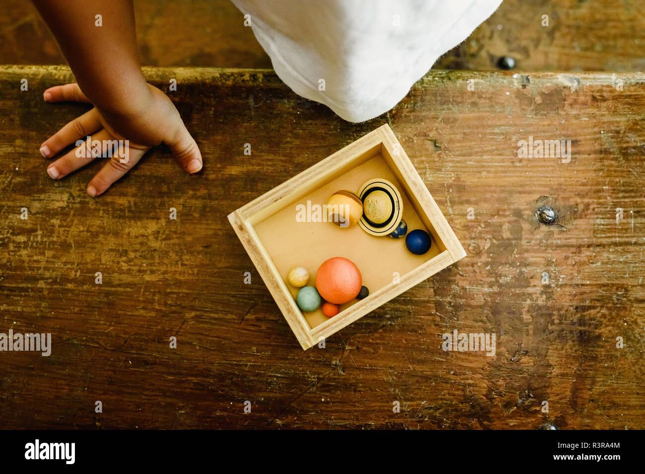 Child playing with small toy planets on an old wooden table Stock Photo ...