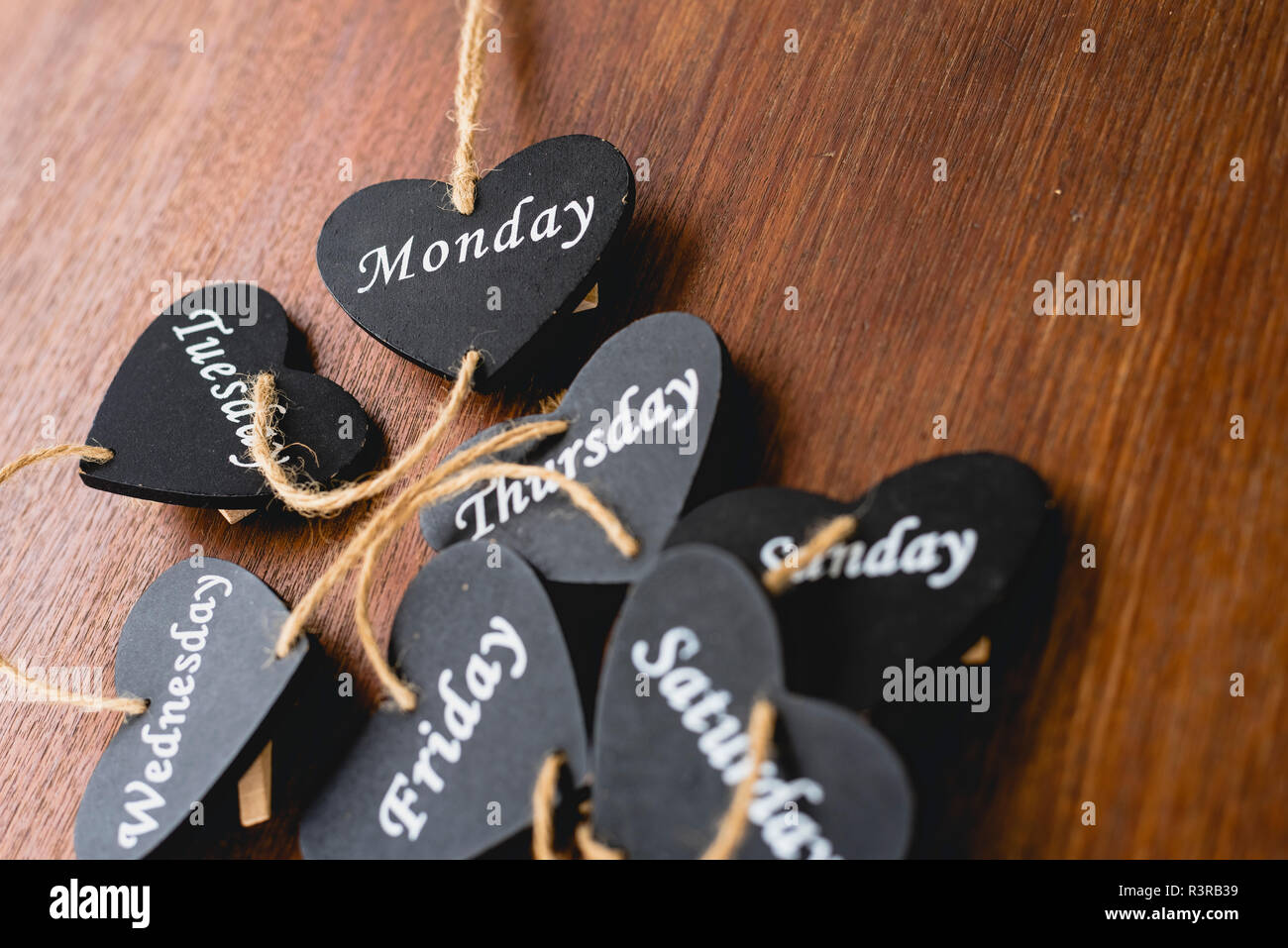 Heart of black wood with days of the weekend written on it Stock Photo ...