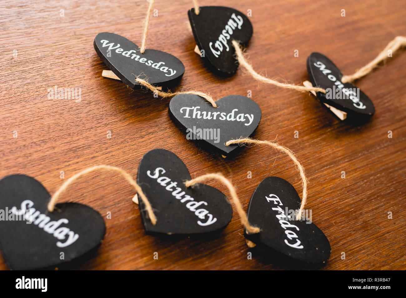 Heart of black wood with days of the weekend written on it Stock Photo ...