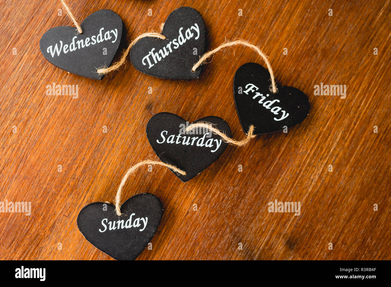Heart of black wood with days of the weekend written on it Stock Photo ...