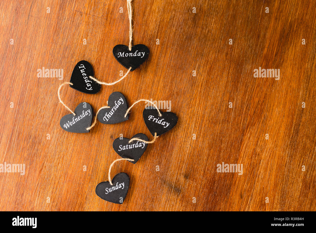 Heart of black wood with days of the weekend written on it Stock Photo ...