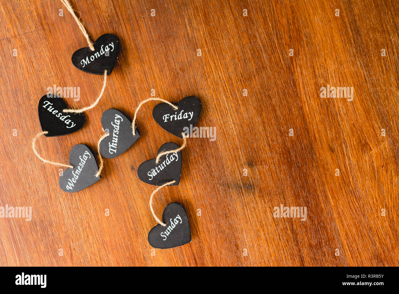 Heart of black wood with days of the weekend written on it Stock Photo ...