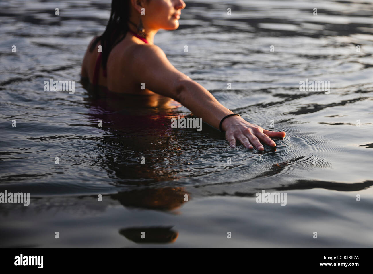 Hand of young woman touching the water surface in a lake Stock Photo ...
