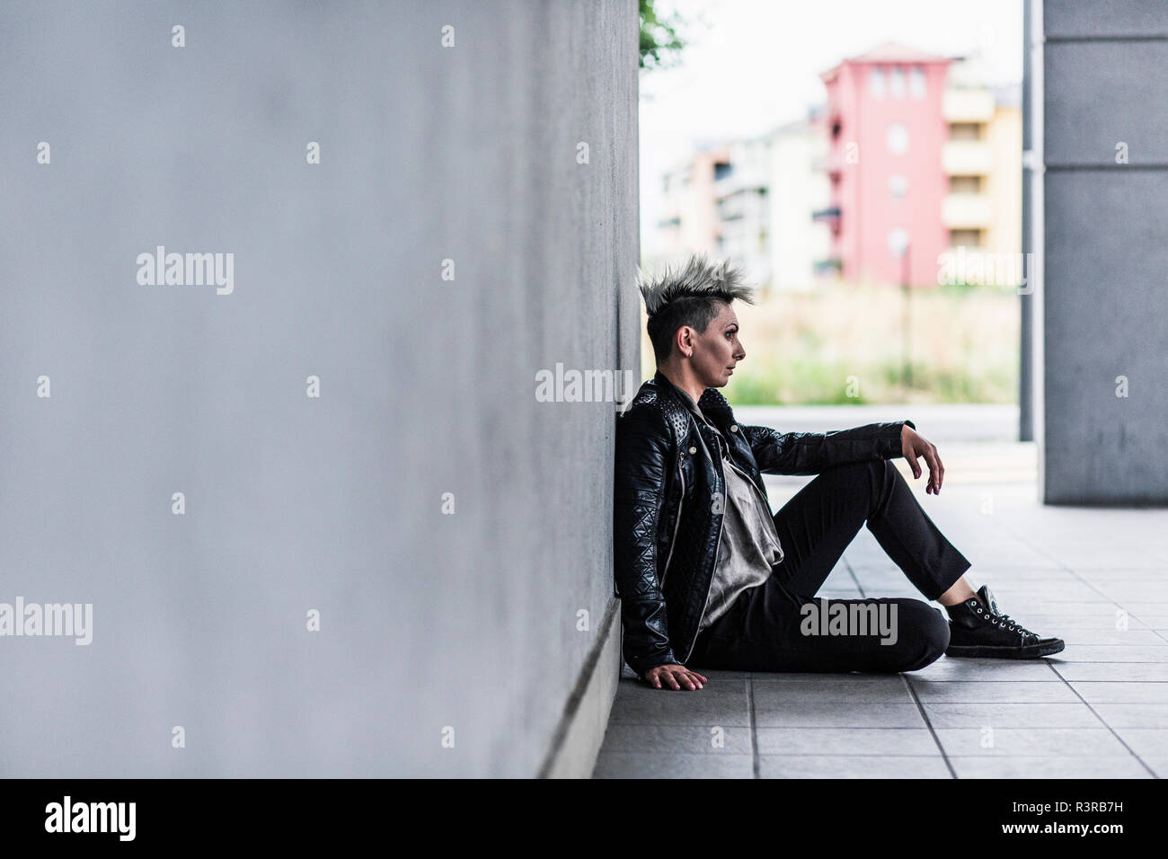 Back view woman sitting on wall hi-res stock photography and images - Alamy