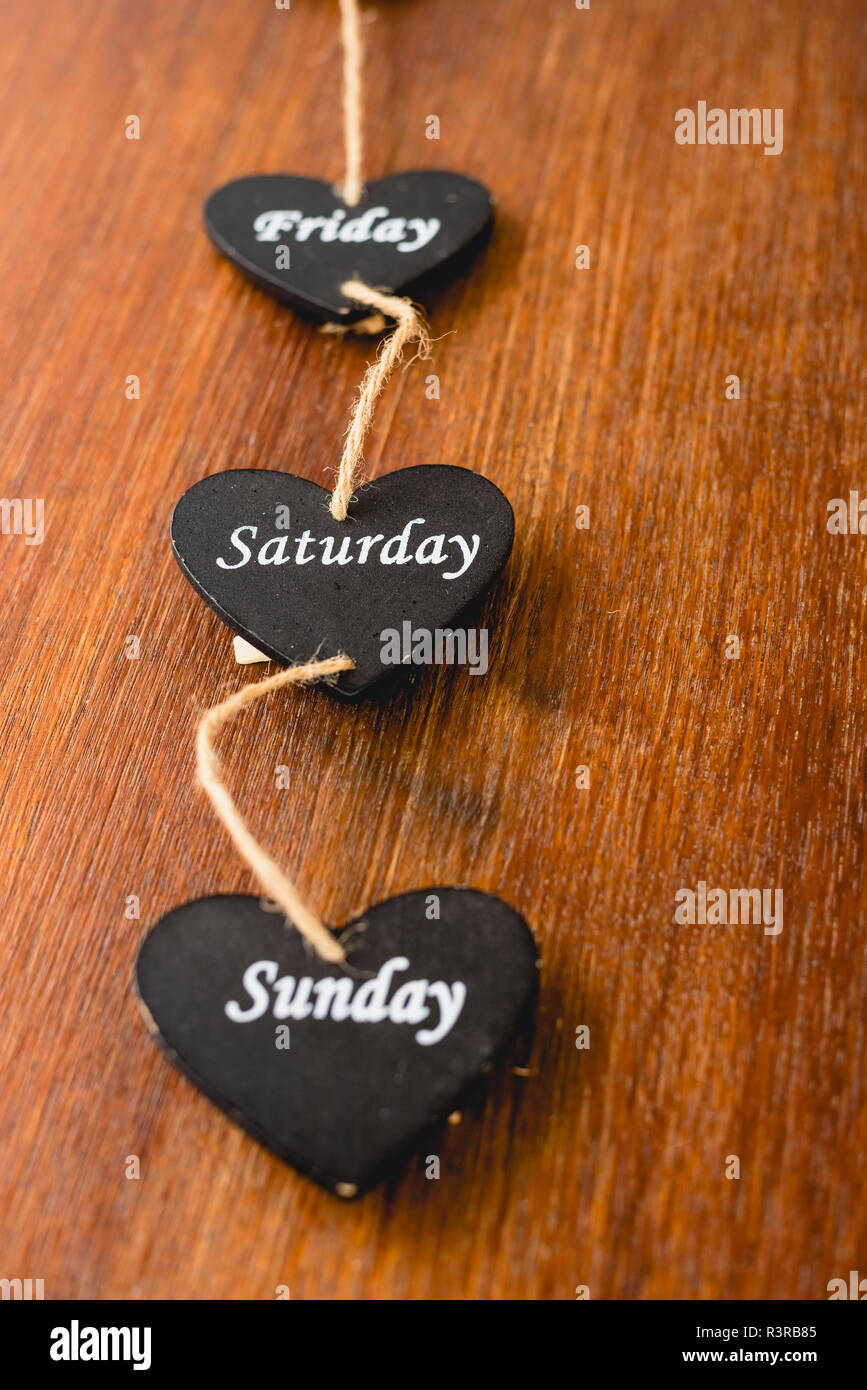 Heart of black wood with days of the weekend written on it Stock Photo ...